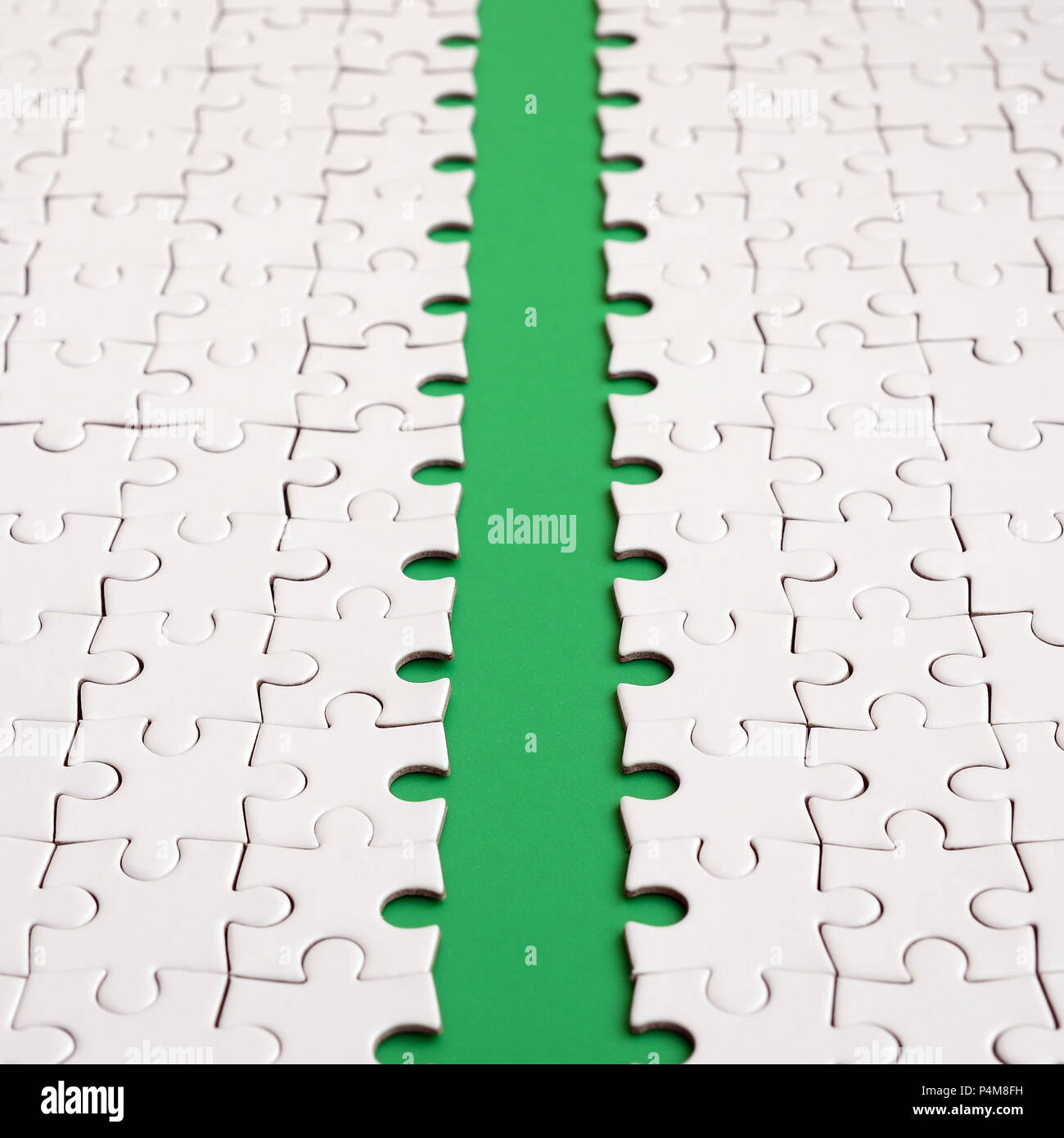 The green path is laid on the platform of a white folded jigsaw puzzle ...