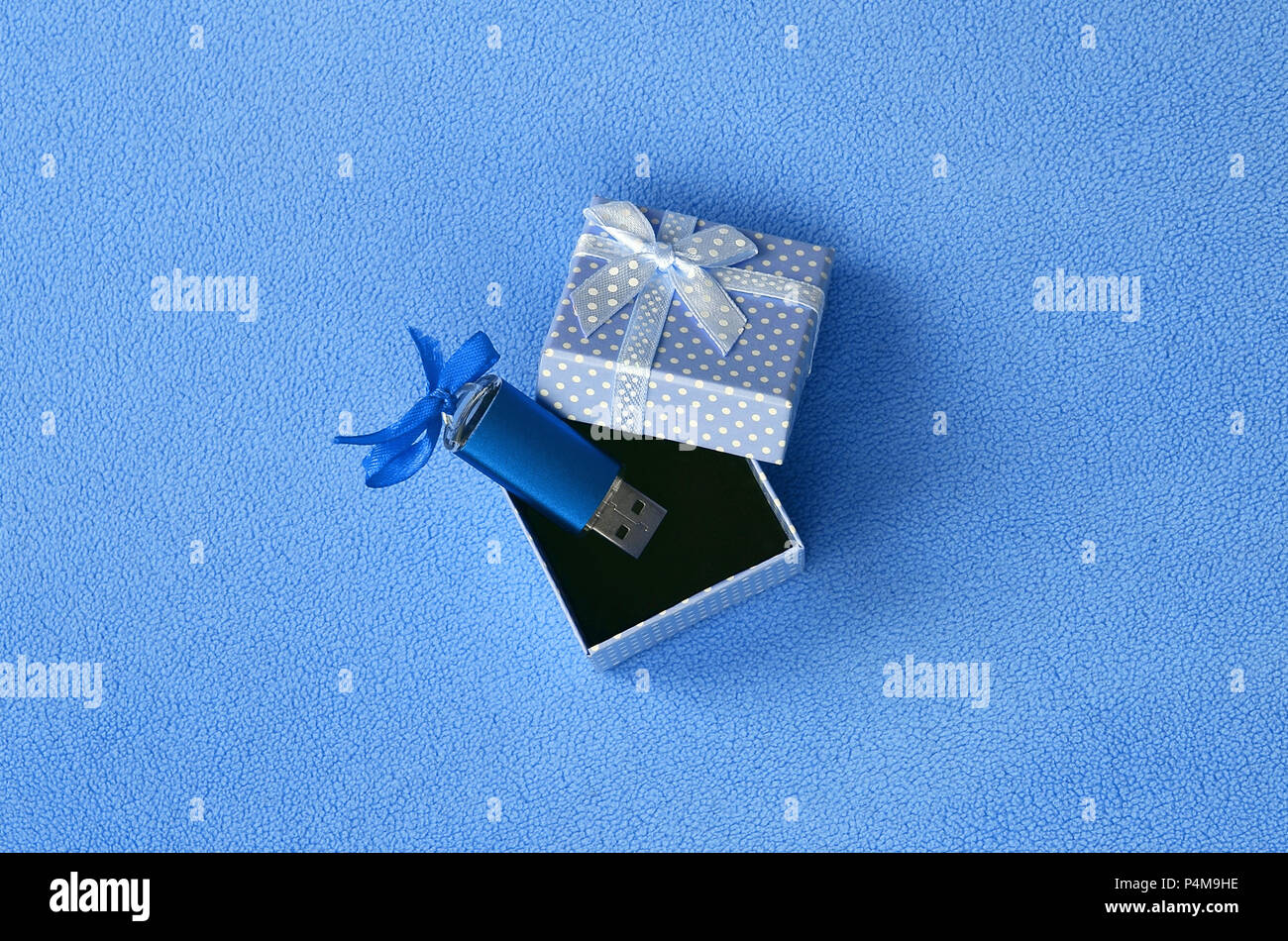Brilliant blue usb flash memory card with a blue bow lies in a small ...