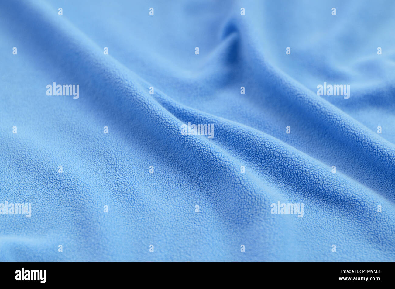 The blanket of furry blue fleece fabric. A background of light blue ...