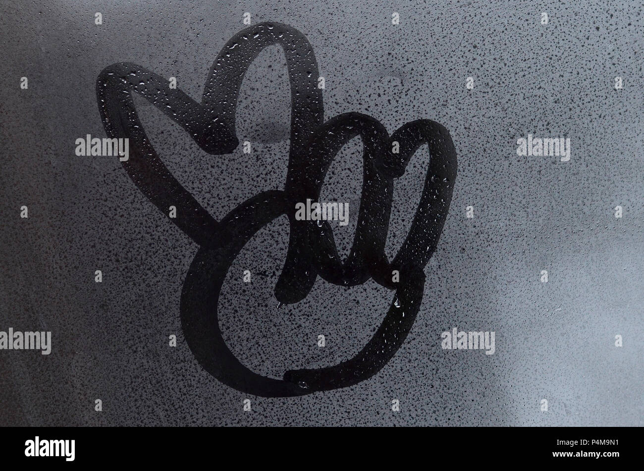 The image of the peace symbol is drawn with a finger on the surface of ...