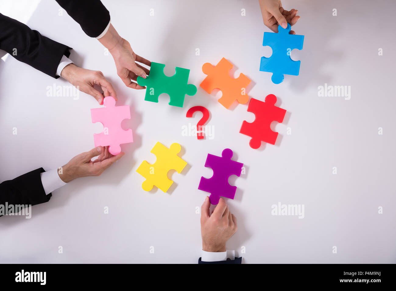 Group Of Businesspeople Holding Jigsaw Puzzle With Question Mark On ...