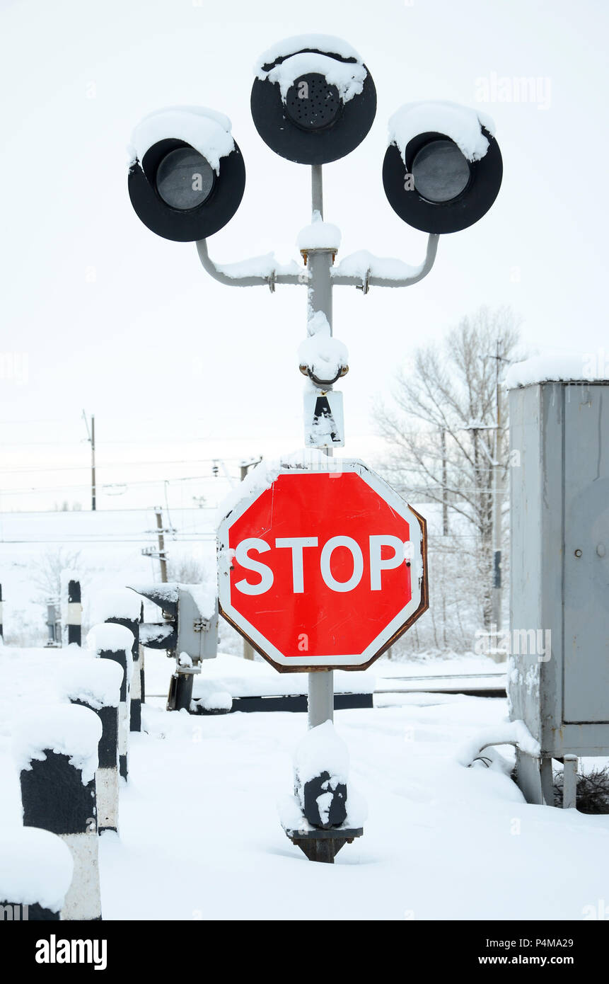 Stop. Red road sign is located on the motorway crossing the railway ...