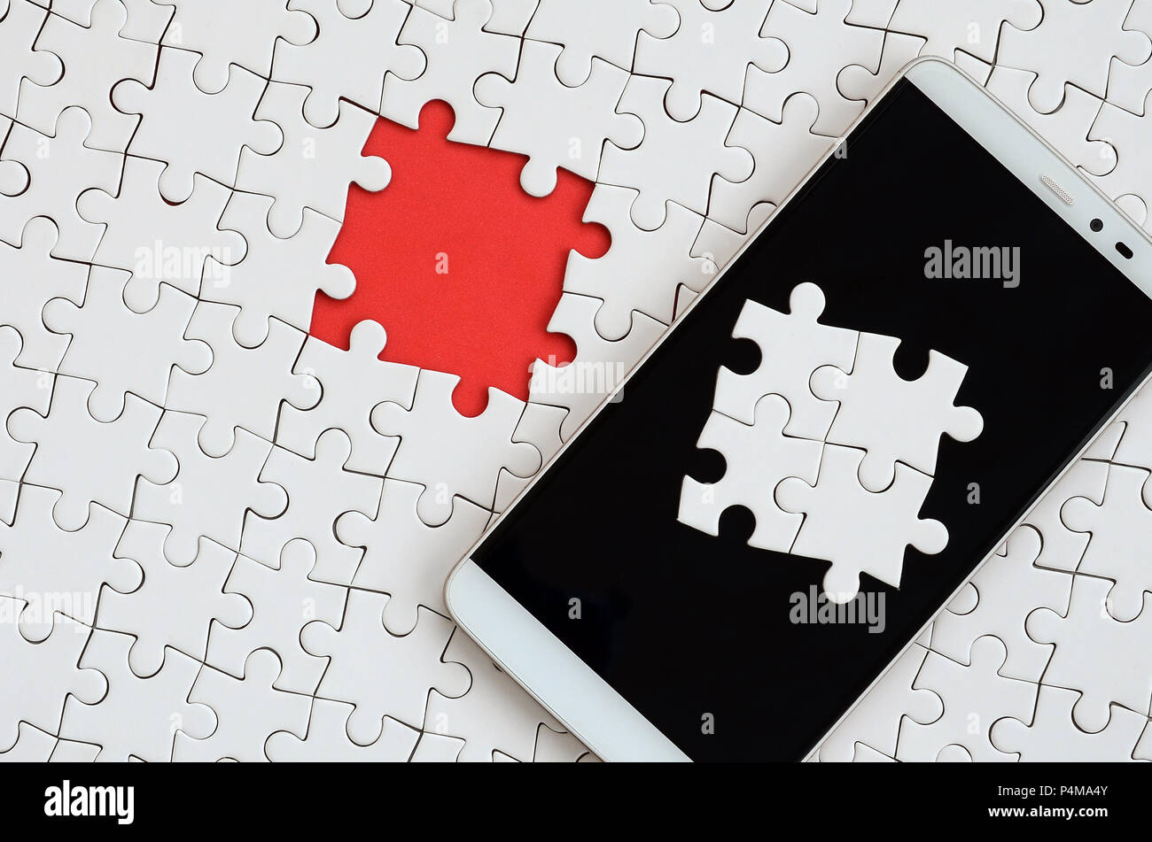 A modern big smartphone with several puzzle elements on the touch ...