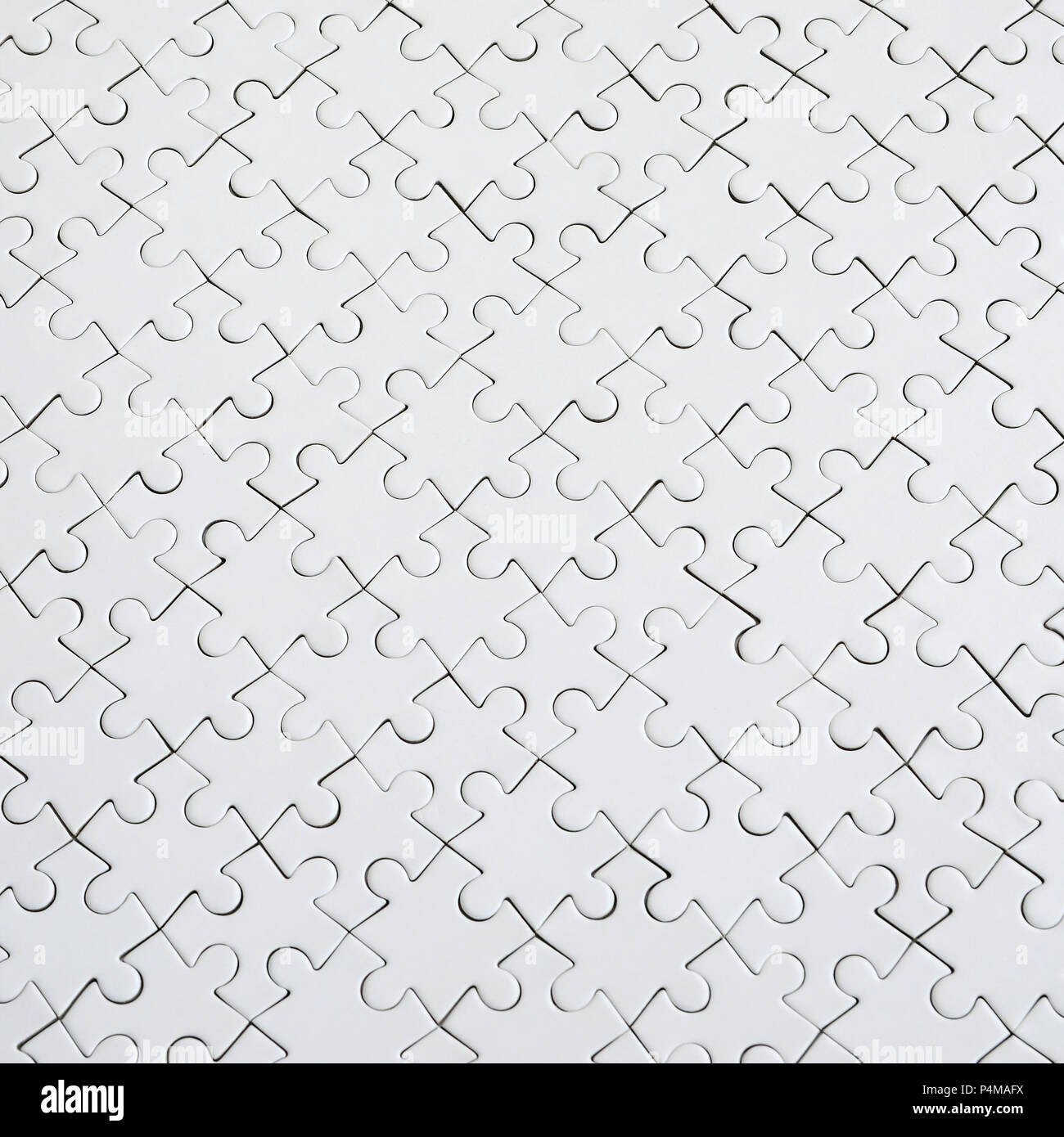 Close up texture of a white jigsaw puzzle in assembled condition. Top ...