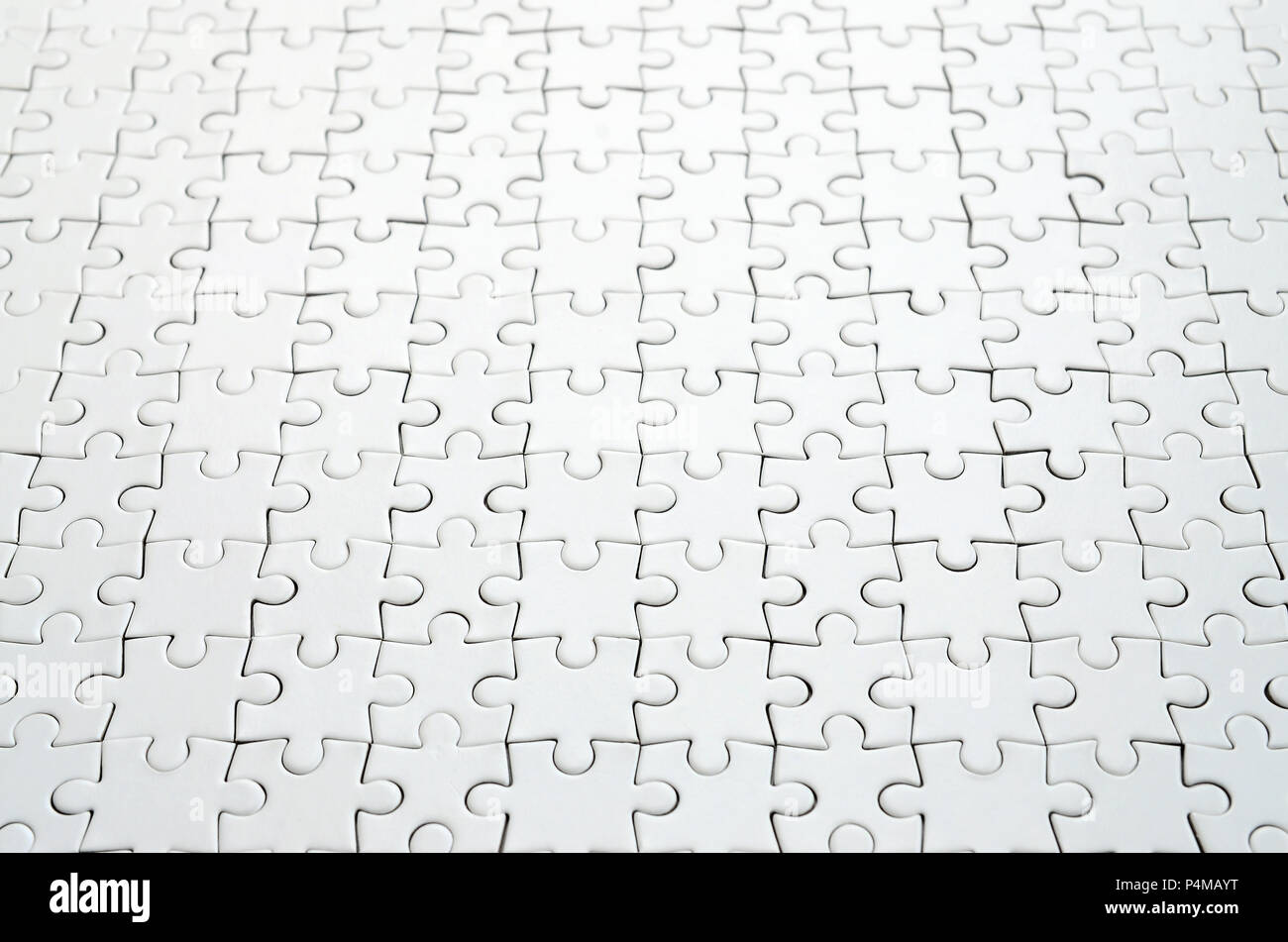 Close up of a white jigsaw puzzle in assembled state in perspective ...