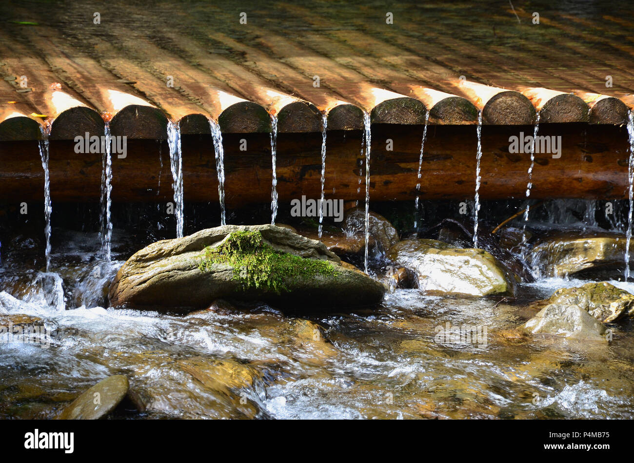 Handmade wooden water drains from small treated beams. A beautiful ...
