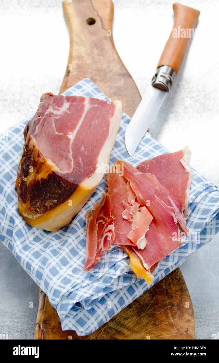 Spanish Serrano ham, a large piece and slices Stock Photo - Alamy