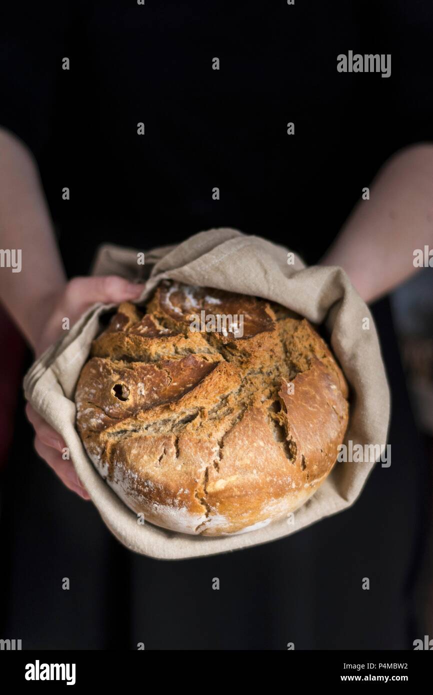 Hands holding clay pot baked beer bread Stock Photo - Alamy