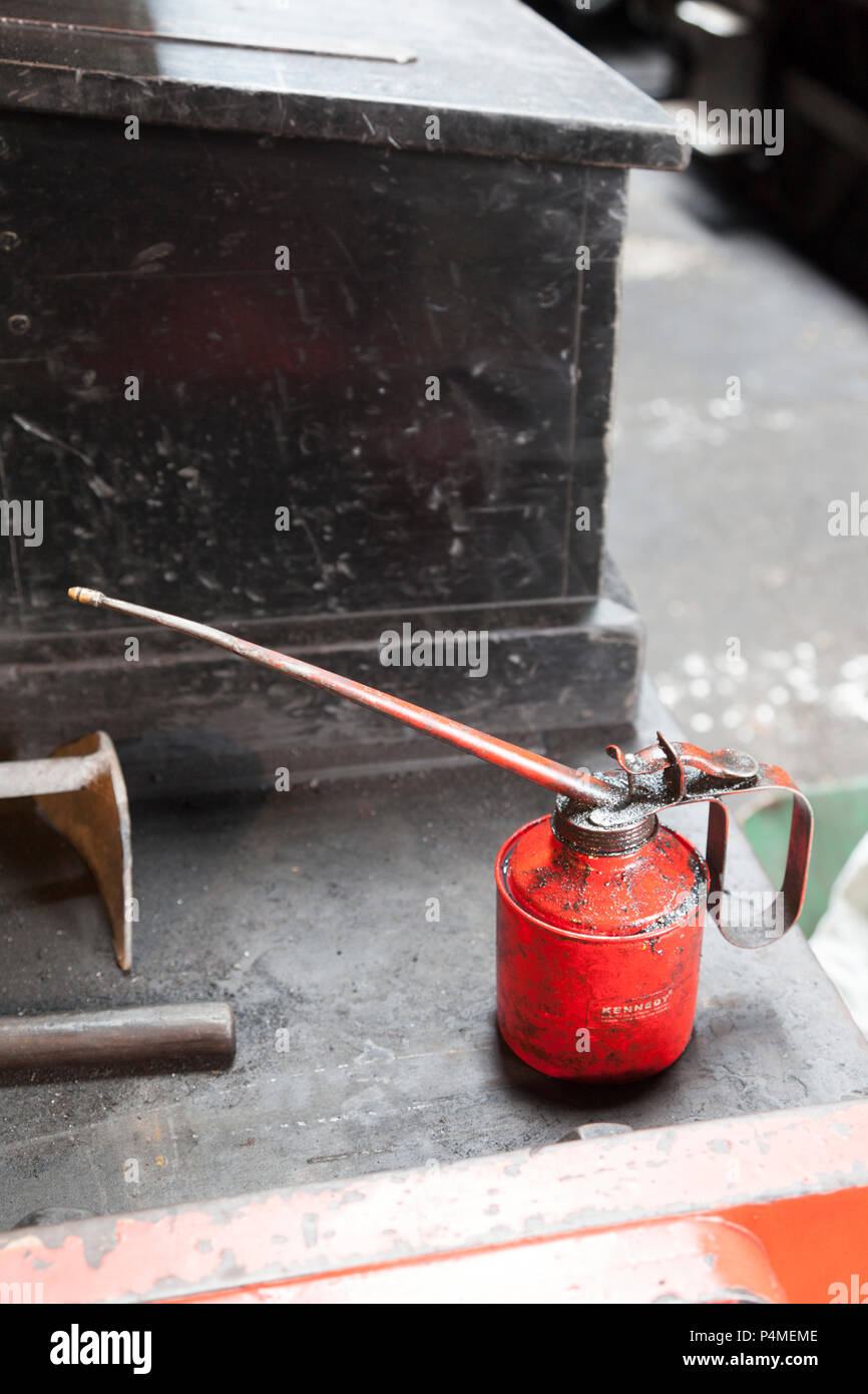 An old red oil can on a work bench Stock Photo - Alamy