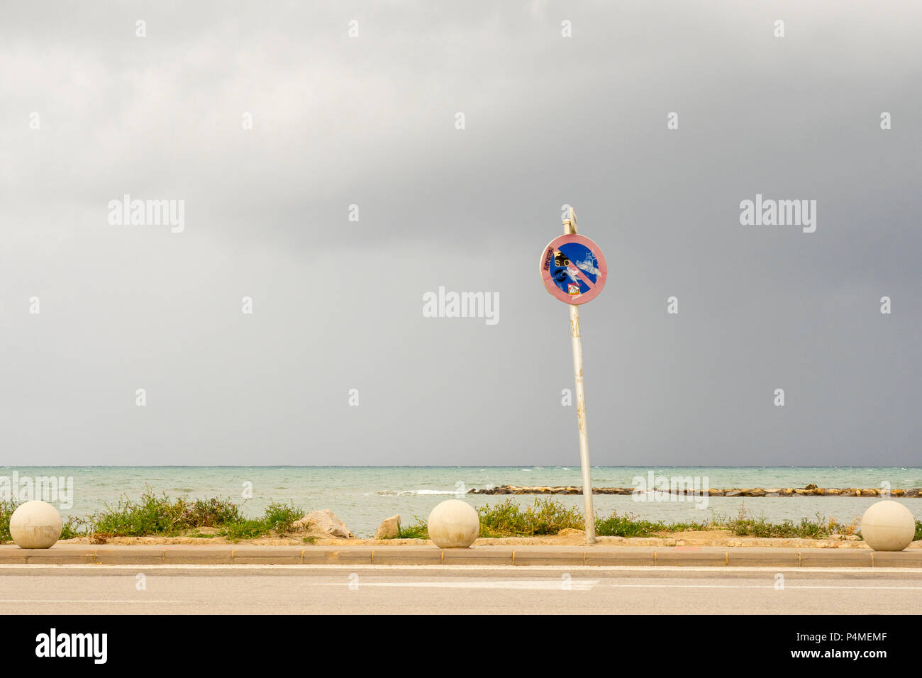 A road sign defaced with stickers, on a road by the sea Stock Photo - Alamy