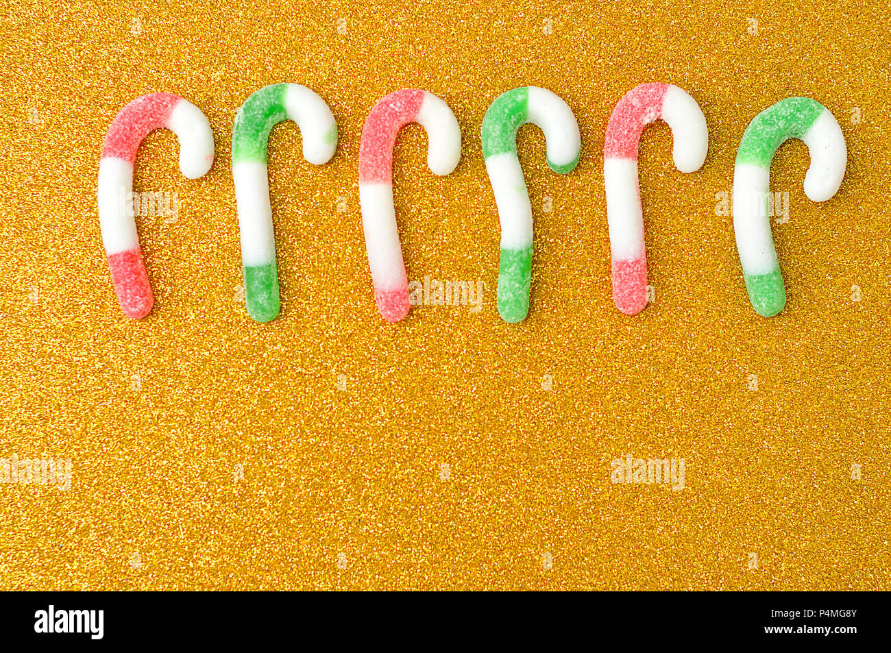 A row of candy canes on a golden background Stock Photo - Alamy