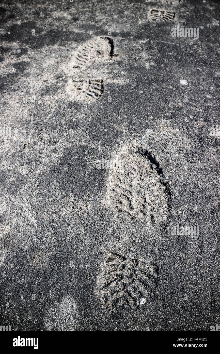 Shoeprints imprinted on the gray asphalt pavement Stock Photo - Alamy