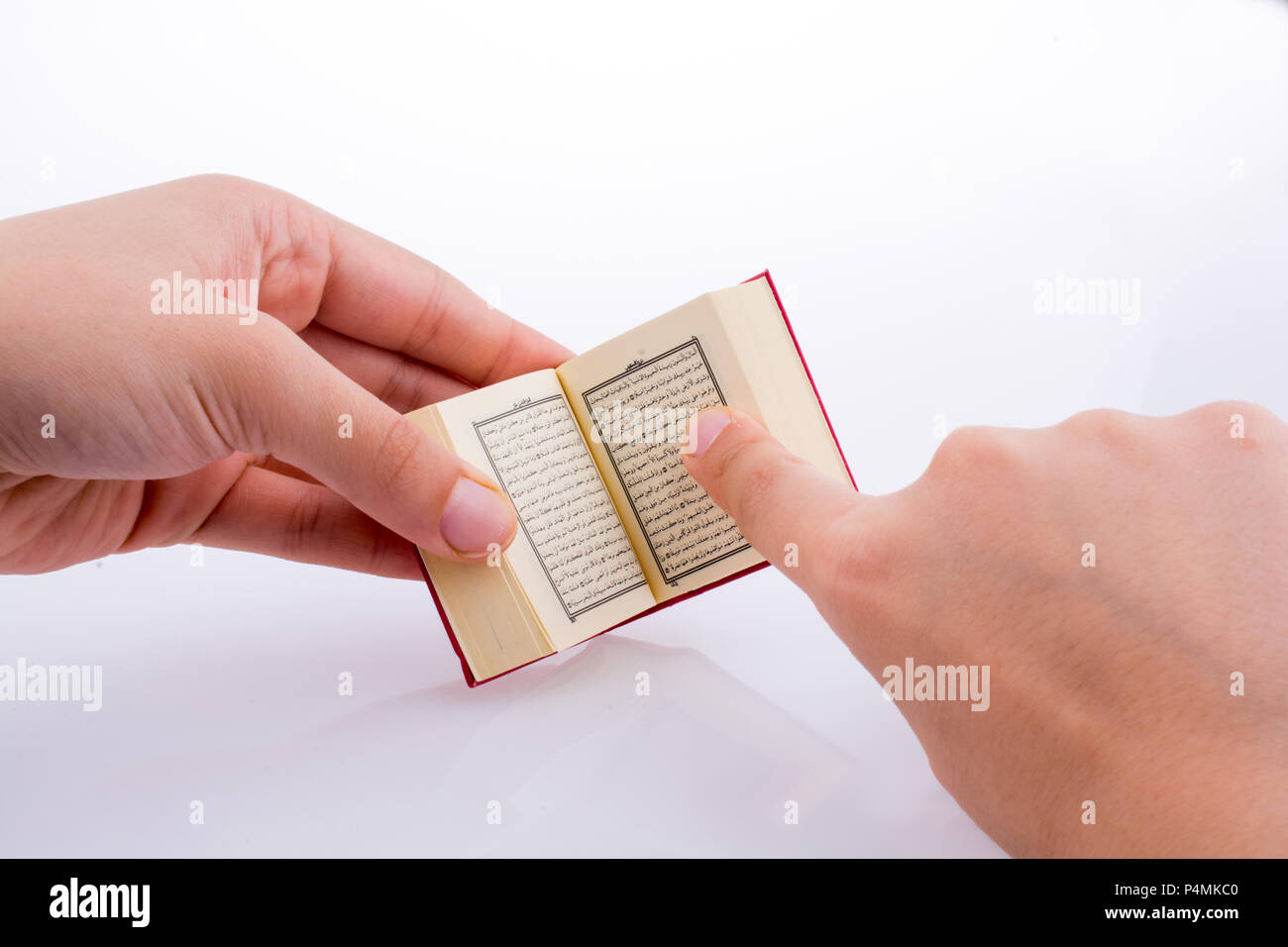 Hand holding The Holy Quran on a white background Stock Photo - Alamy