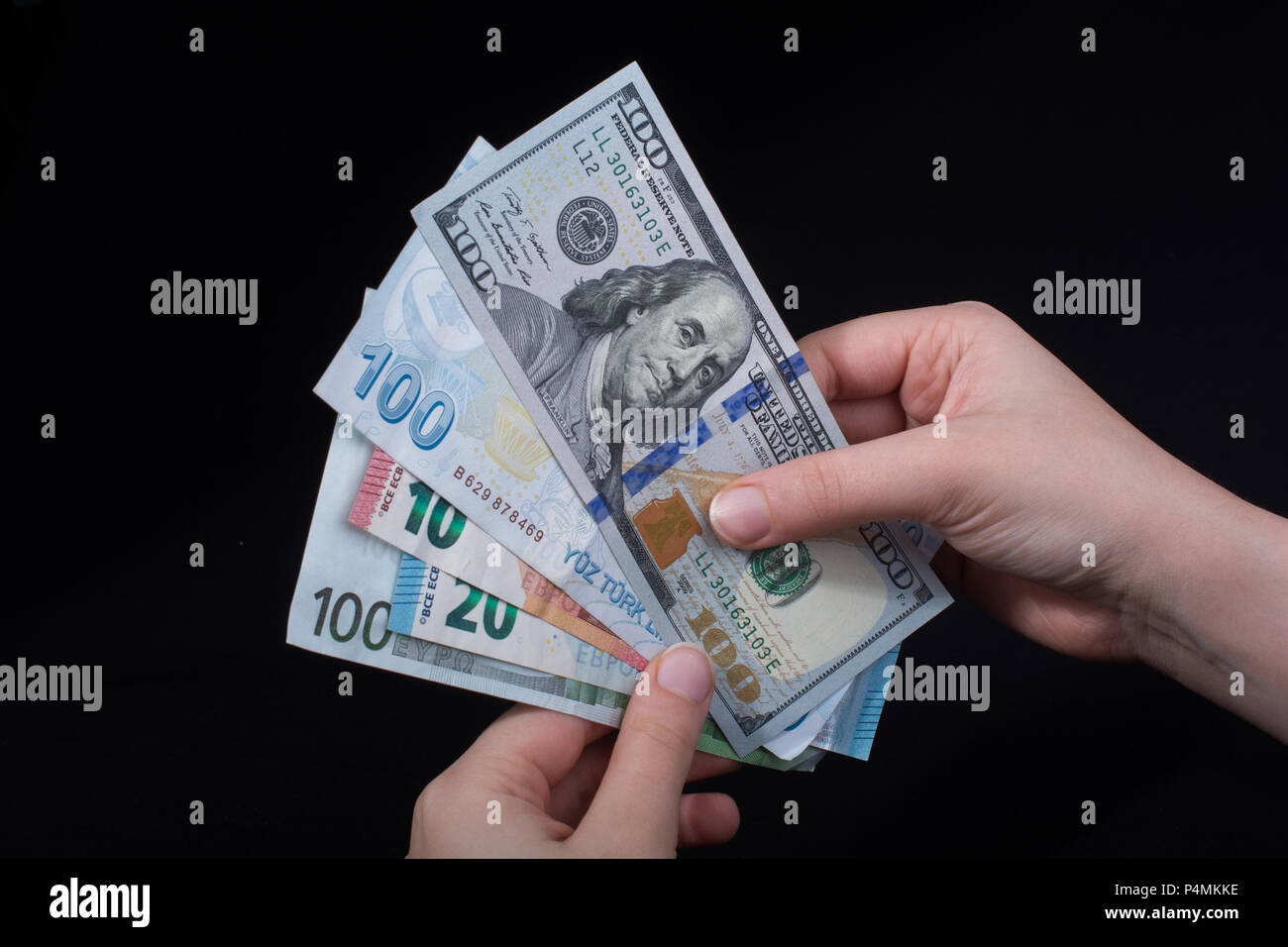 Hand holding American dollar banknotes isolated on black background ...