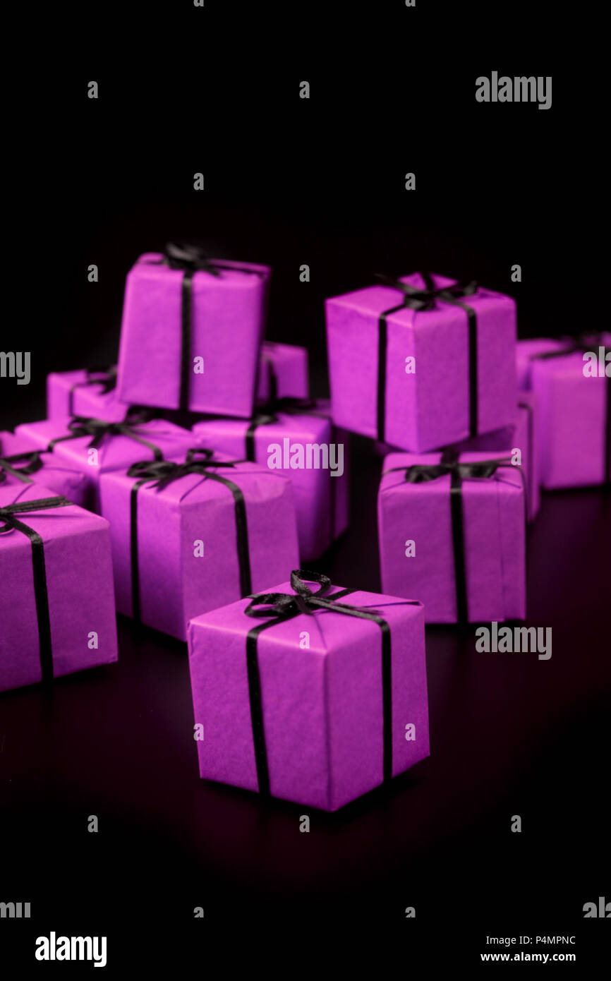 many violet gift boxes on black background Stock Photo - Alamy