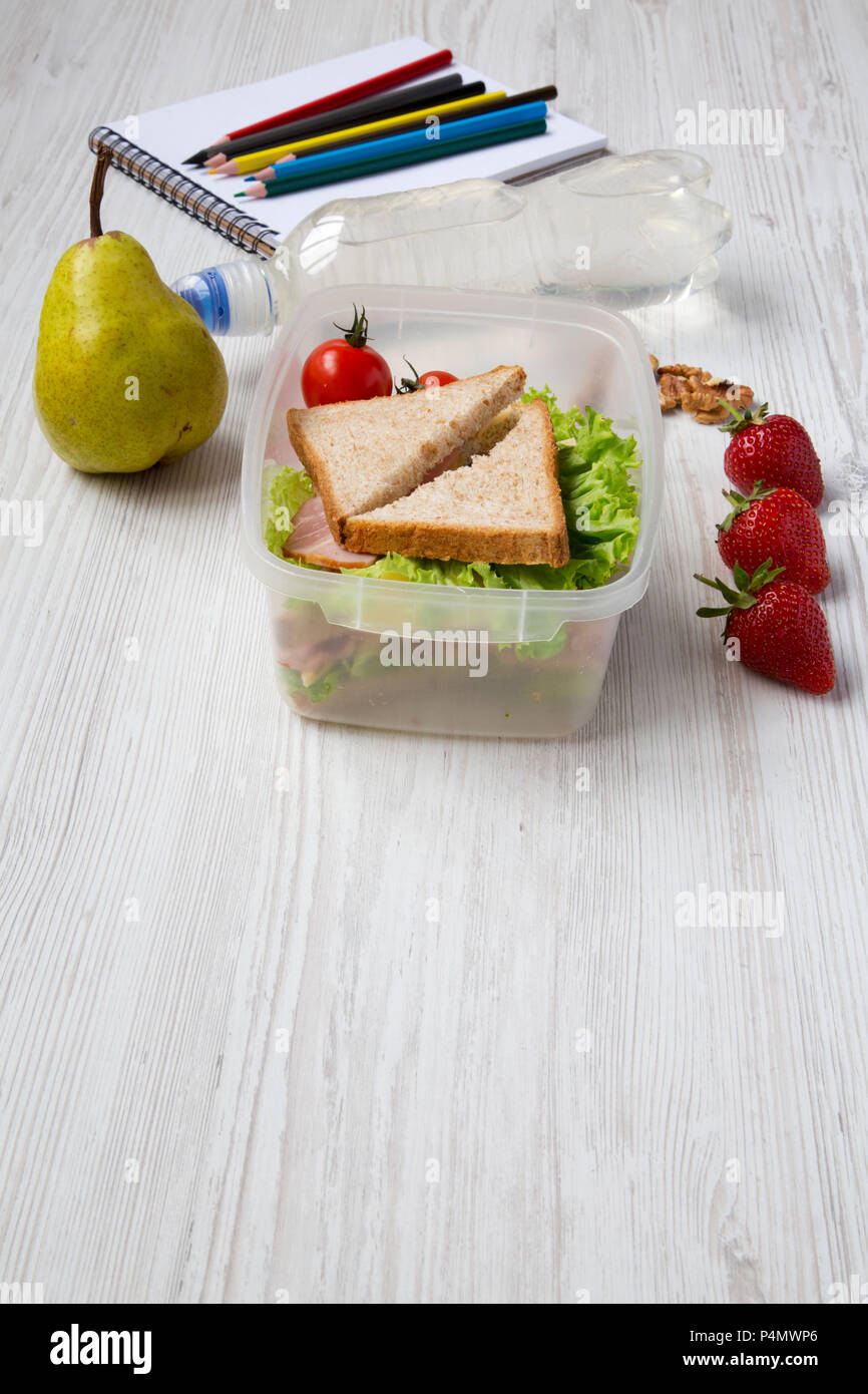 Healthy school lunch box with notebook and color pencils on white ...