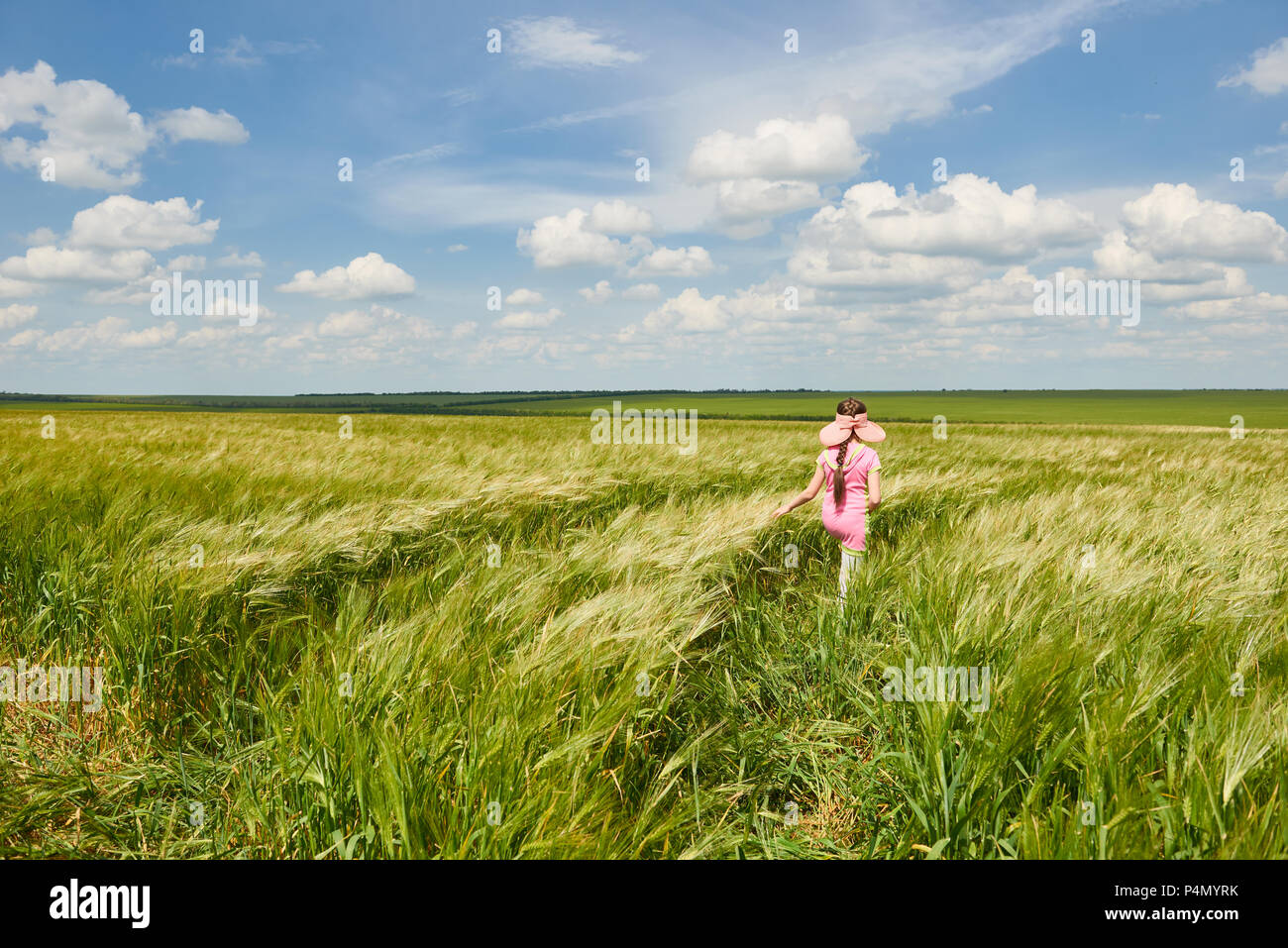 child walking through the wheat field, bright sun, beautiful summer ...