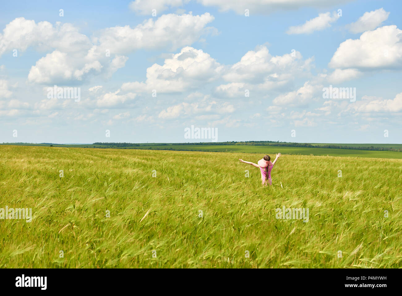 child walking through the wheat field, bright sun, beautiful summer ...