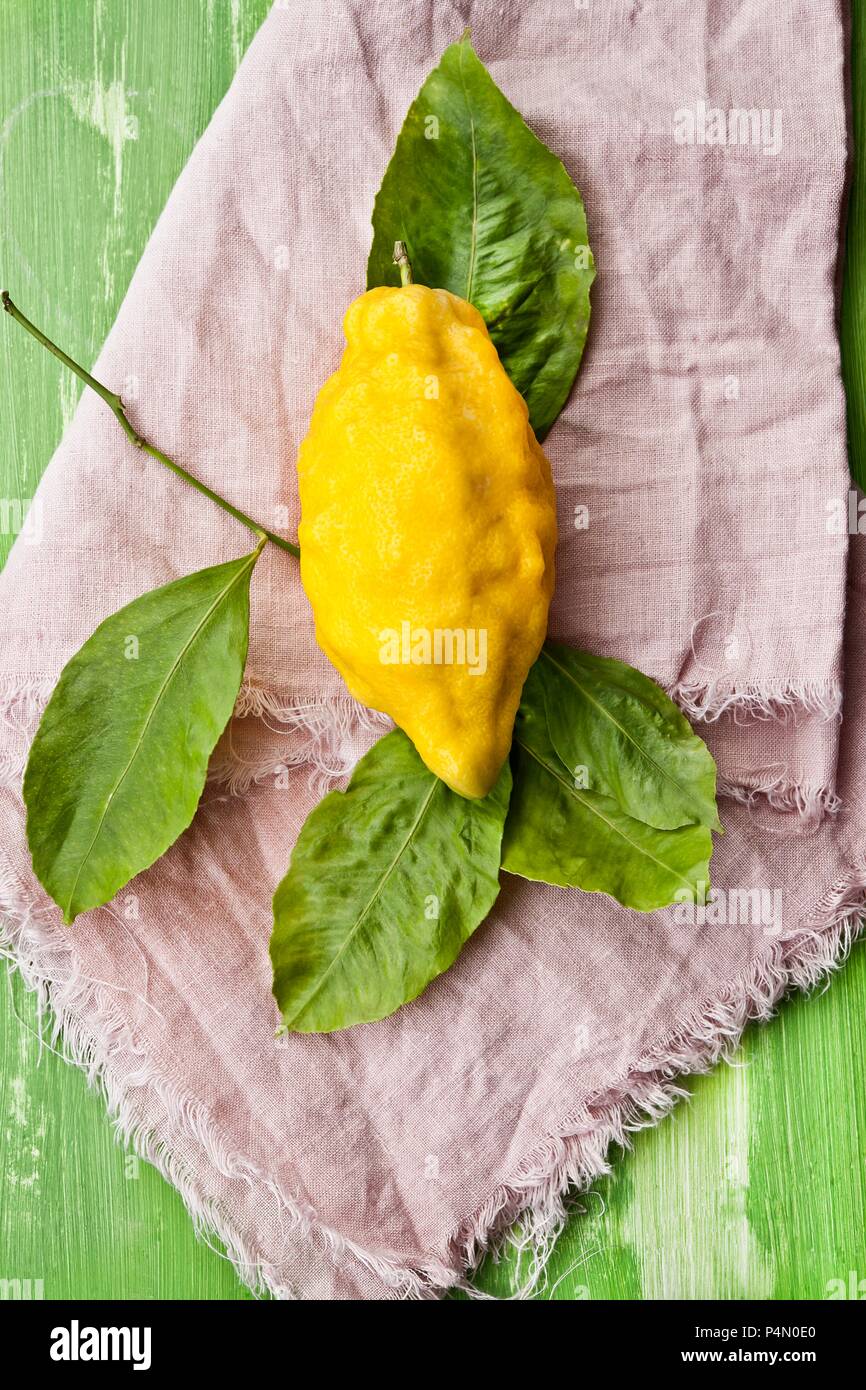 A lemon with leaves on a creased cloth Stock Photo - Alamy
