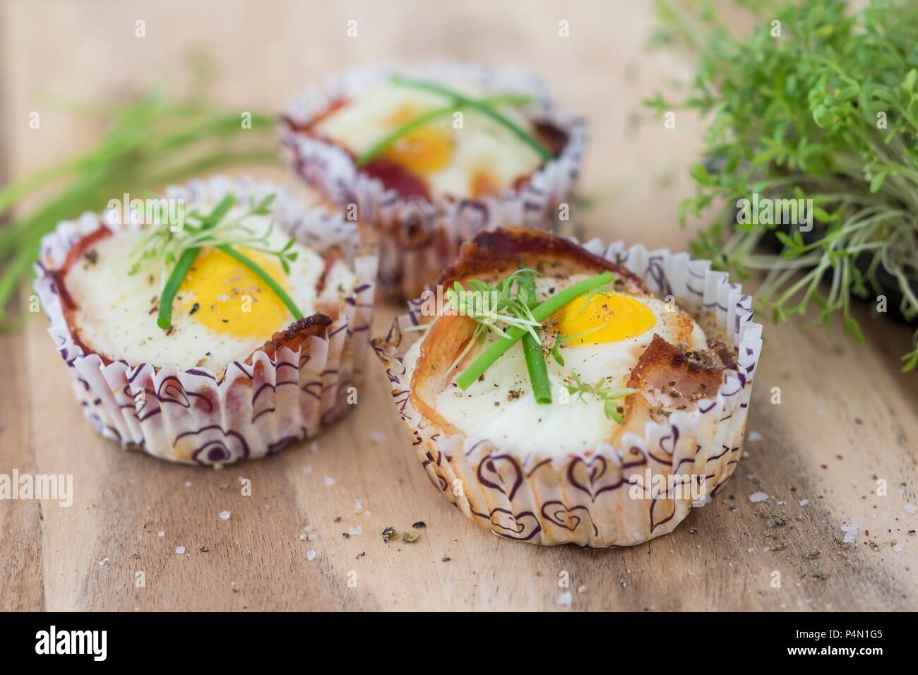 Baked eggs with bacon in paper cases Stock Photo - Alamy