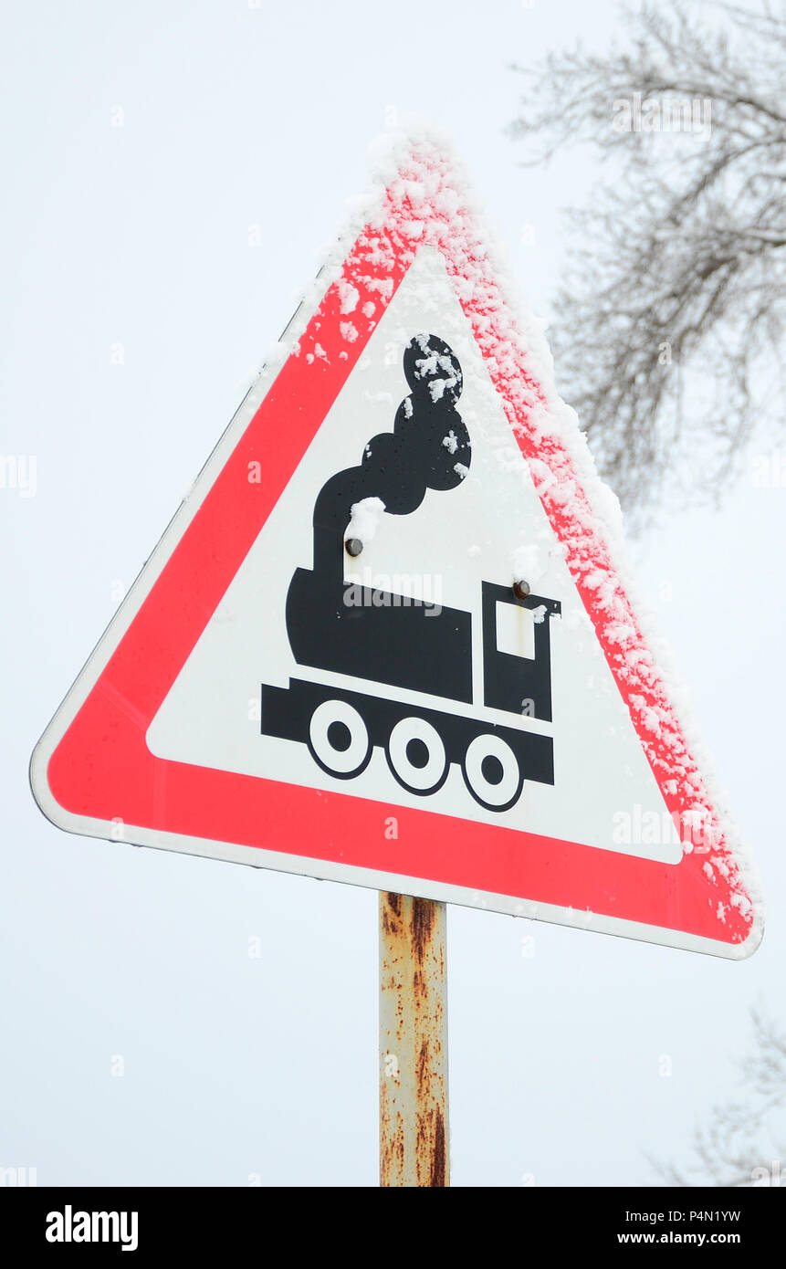 Railway crossing without barrier. A road sign depicting an old black ...
