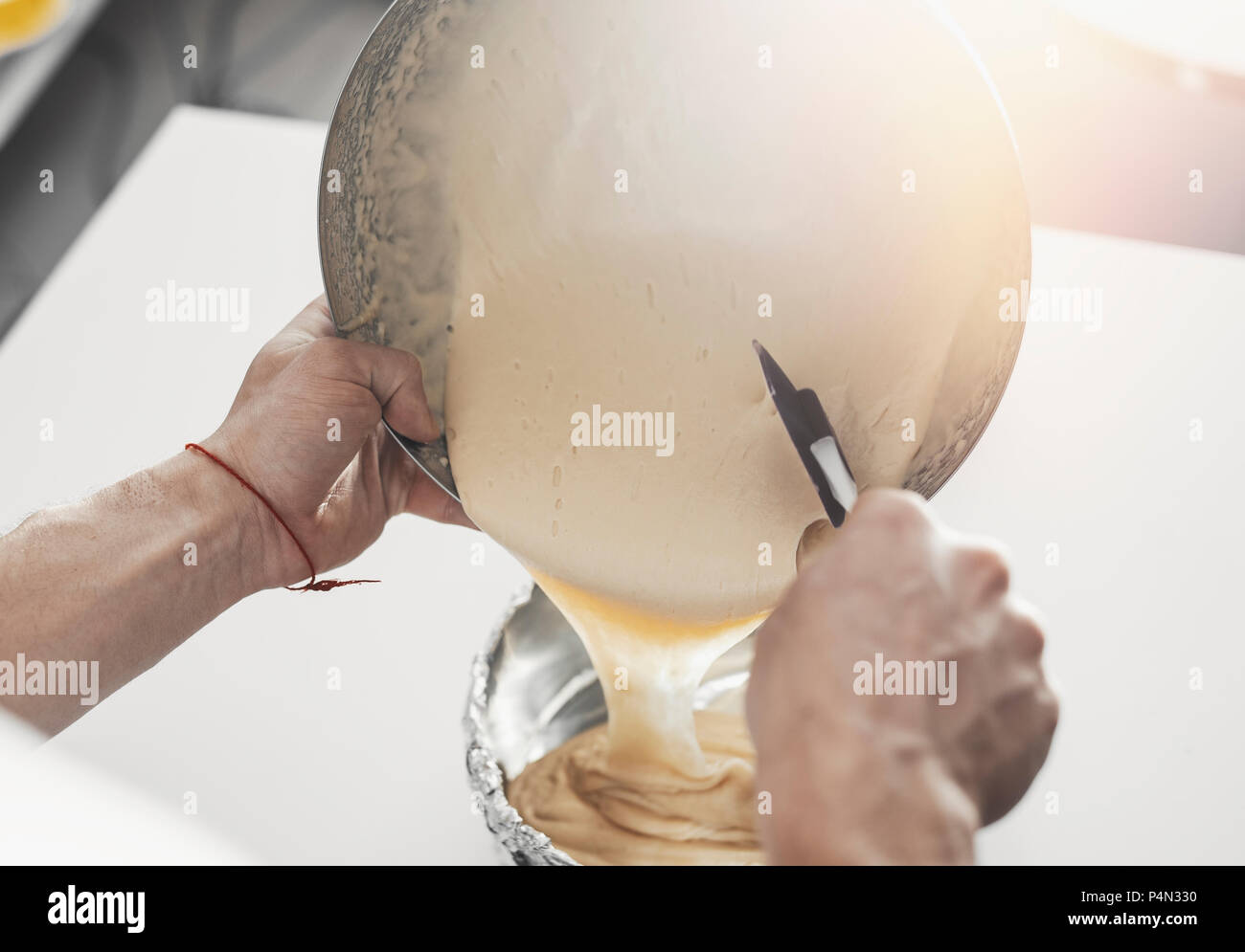 Cook pours dough in big metal plate Stock Photo - Alamy