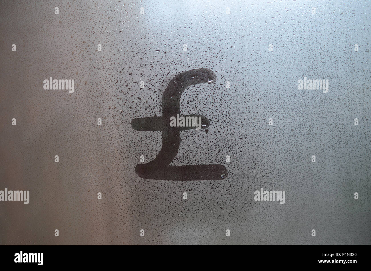 Symbol of English pounds is written with a finger on the surface of the ...