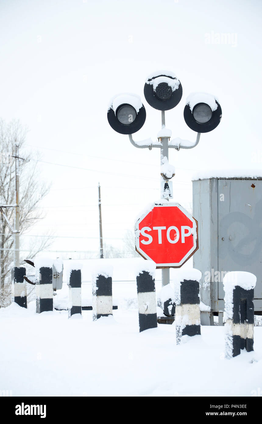 Stop. Red road sign is located on the motorway crossing the railway ...