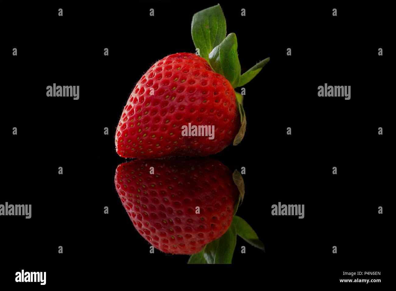 close up front big strawberry with reflection and black background ...