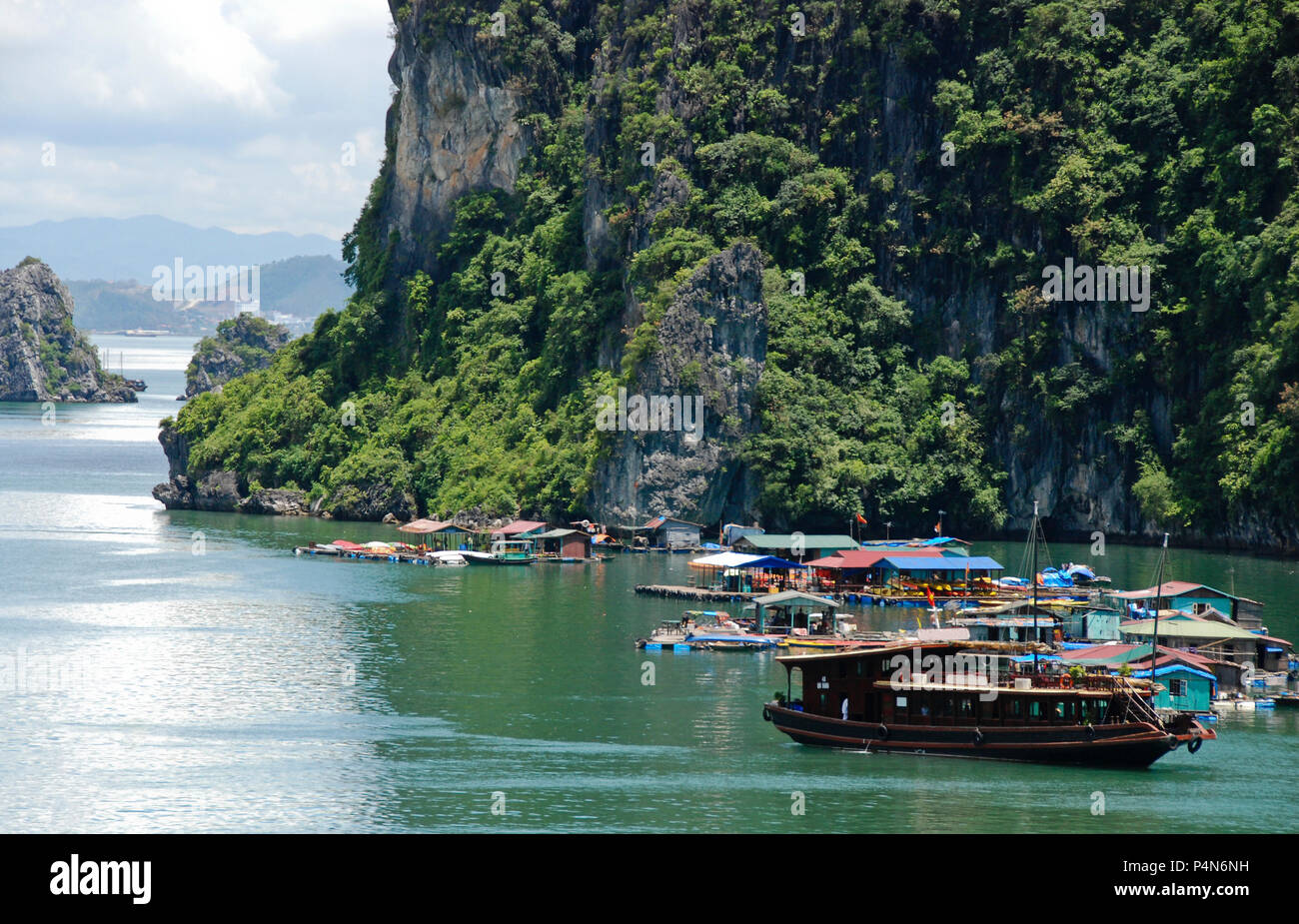 Floating village and tourist boats at the famous Halong Bay area in ...