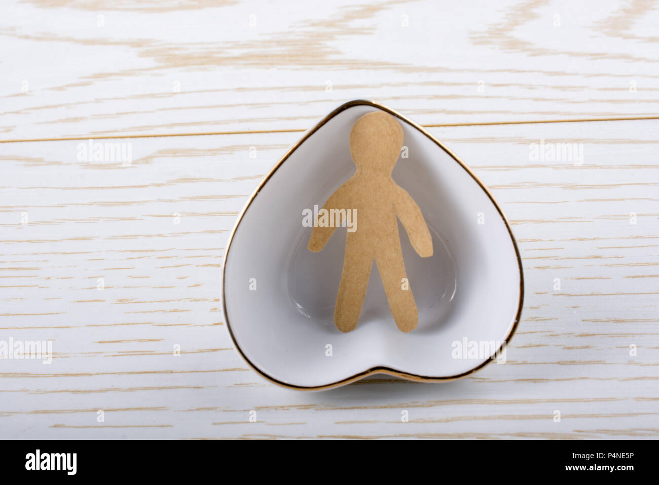 Man shape cut out of paper in hand in the view Stock Photo - Alamy