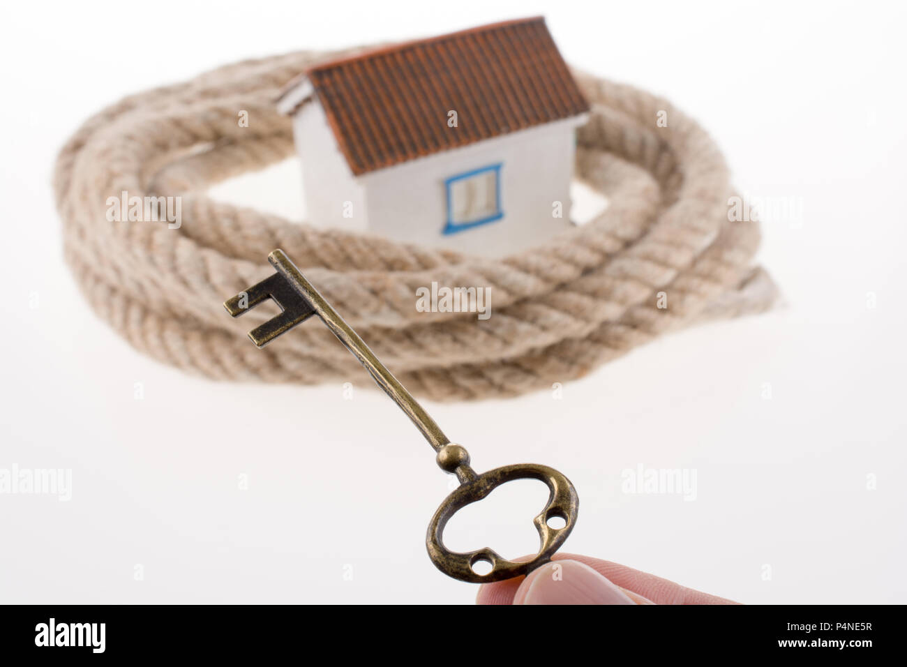 key and house surrounded by rope on a white background Stock Photo - Alamy