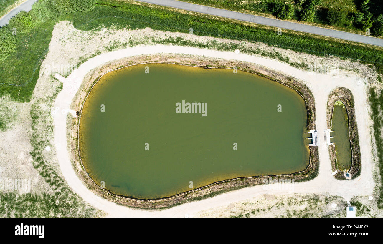Aerial view of a rain retention basin at the edge of a new development ...