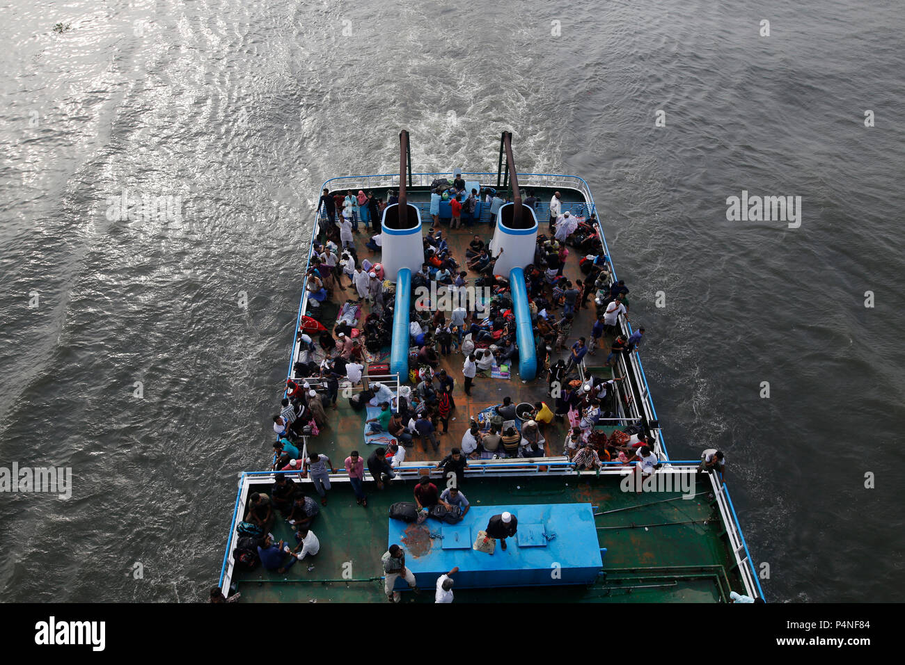People travel on an overcrowded ferry along the Buriganga River in ...