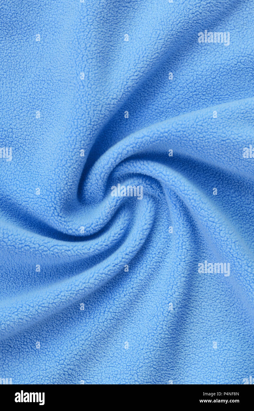 The blanket of furry blue fleece fabric. A background of light blue ...