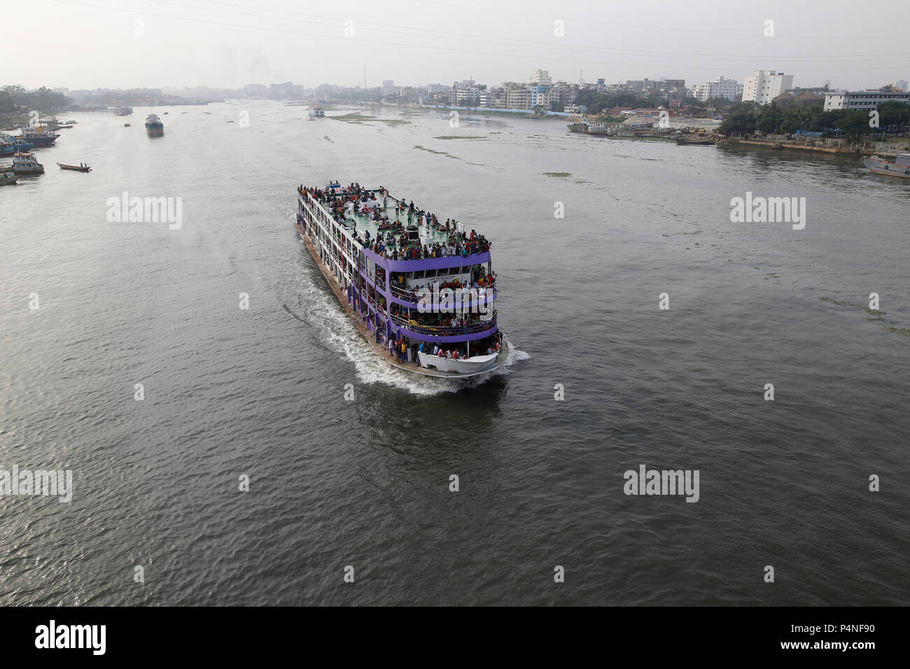 People travel on an overcrowded ferry along the Buriganga River in ...
