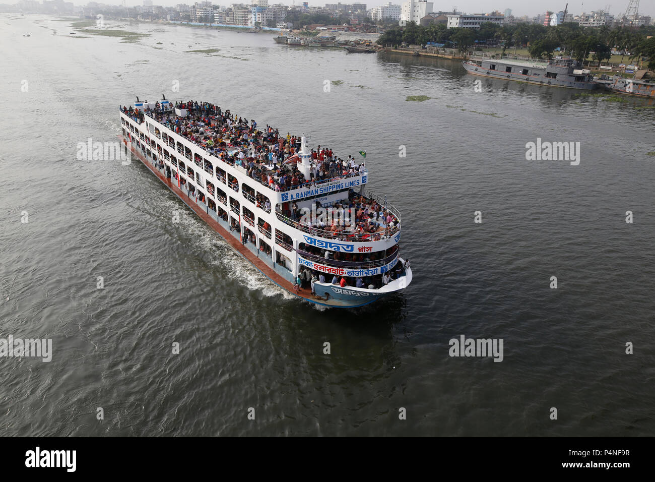 People travel on an overcrowded ferry along the Buriganga River in ...