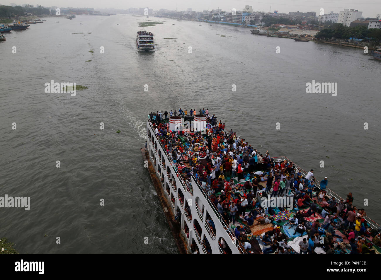 People travel on an overcrowded ferry along the Buriganga River in ...