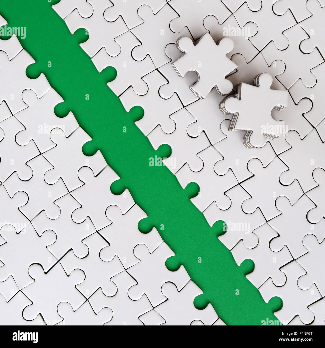 The green path is laid on the platform of a white folded jigsaw puzzle ...