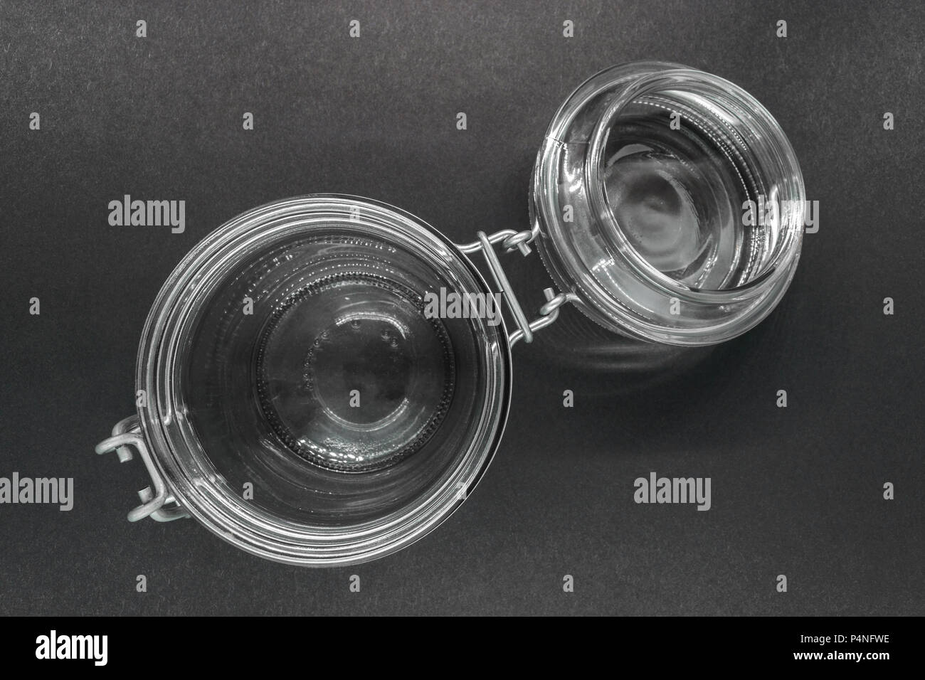 Open glass jar with metal holder on black background surface Stock ...