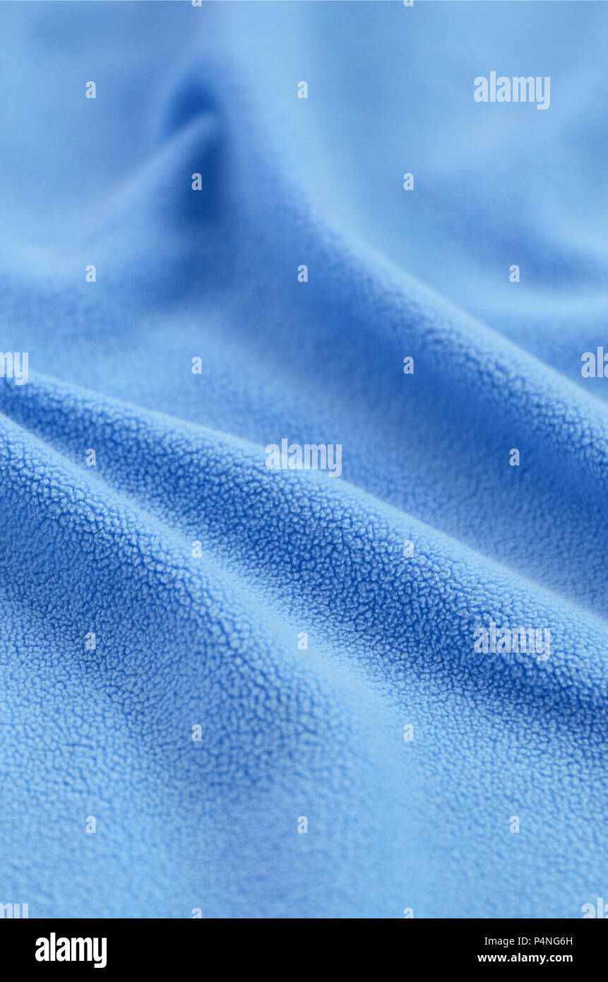 The blanket of furry blue fleece fabric. A background of light blue ...