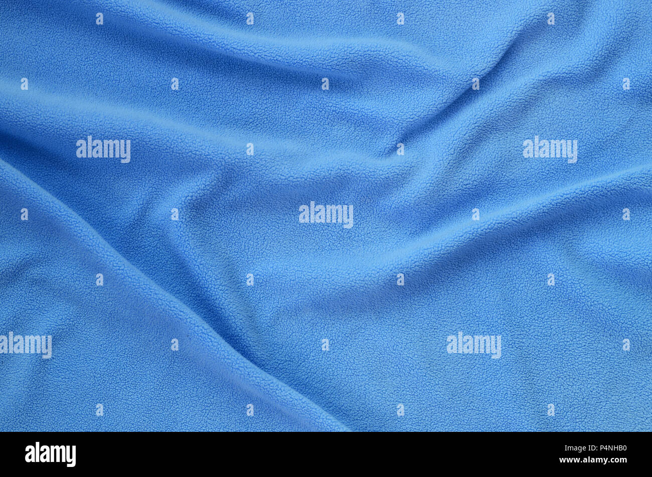 The blanket of furry blue fleece fabric. A background of light blue ...