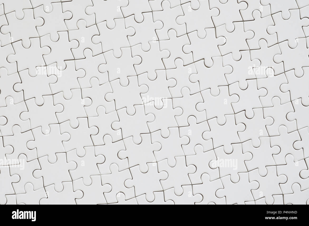 Close up texture of a white jigsaw puzzle in assembled condition. Top ...