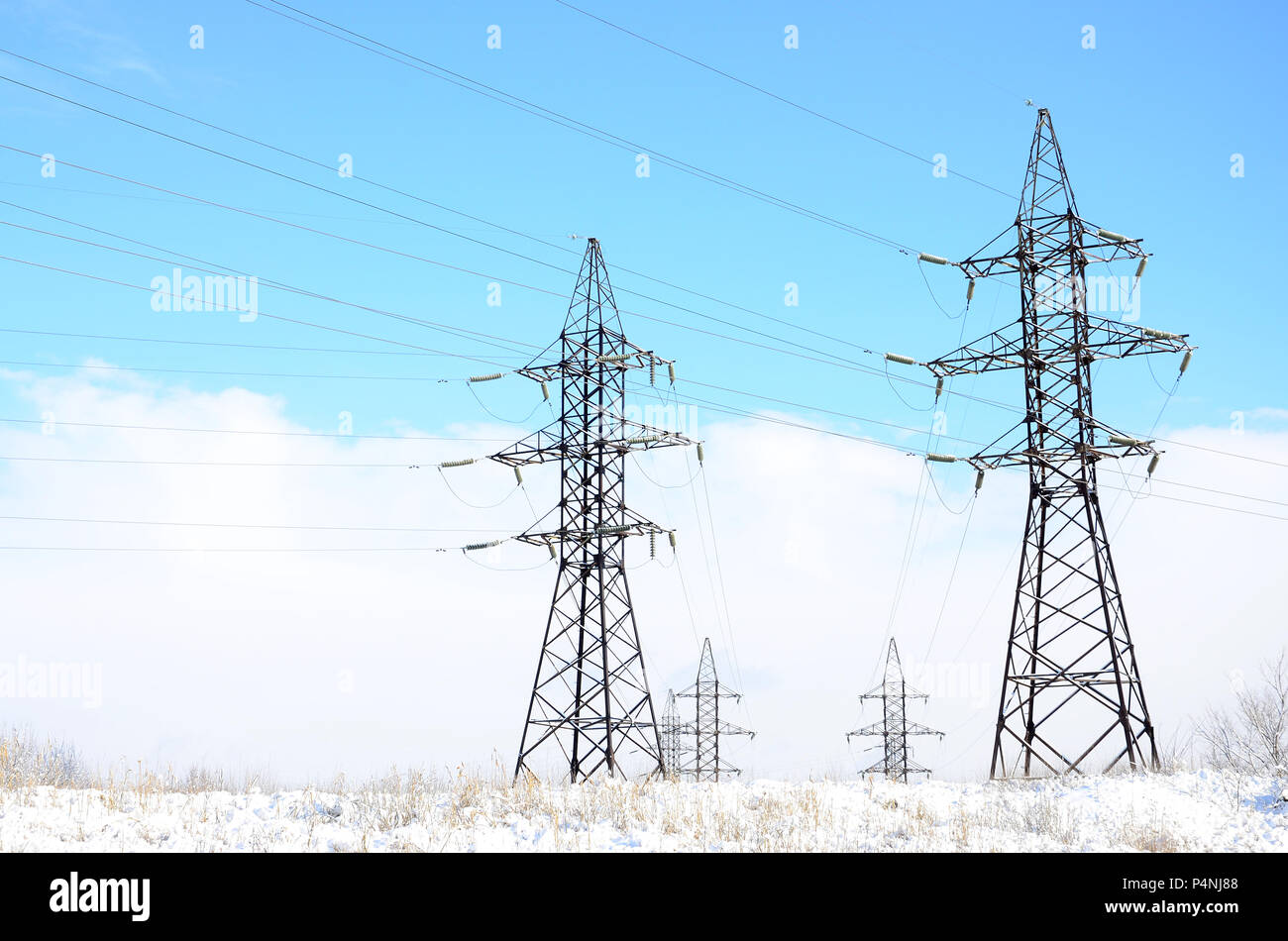 Towers of power lines in the winter field. Electrical equipment Stock ...