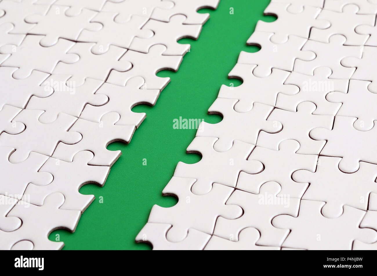 The green path is laid on the platform of a white folded jigsaw puzzle ...
