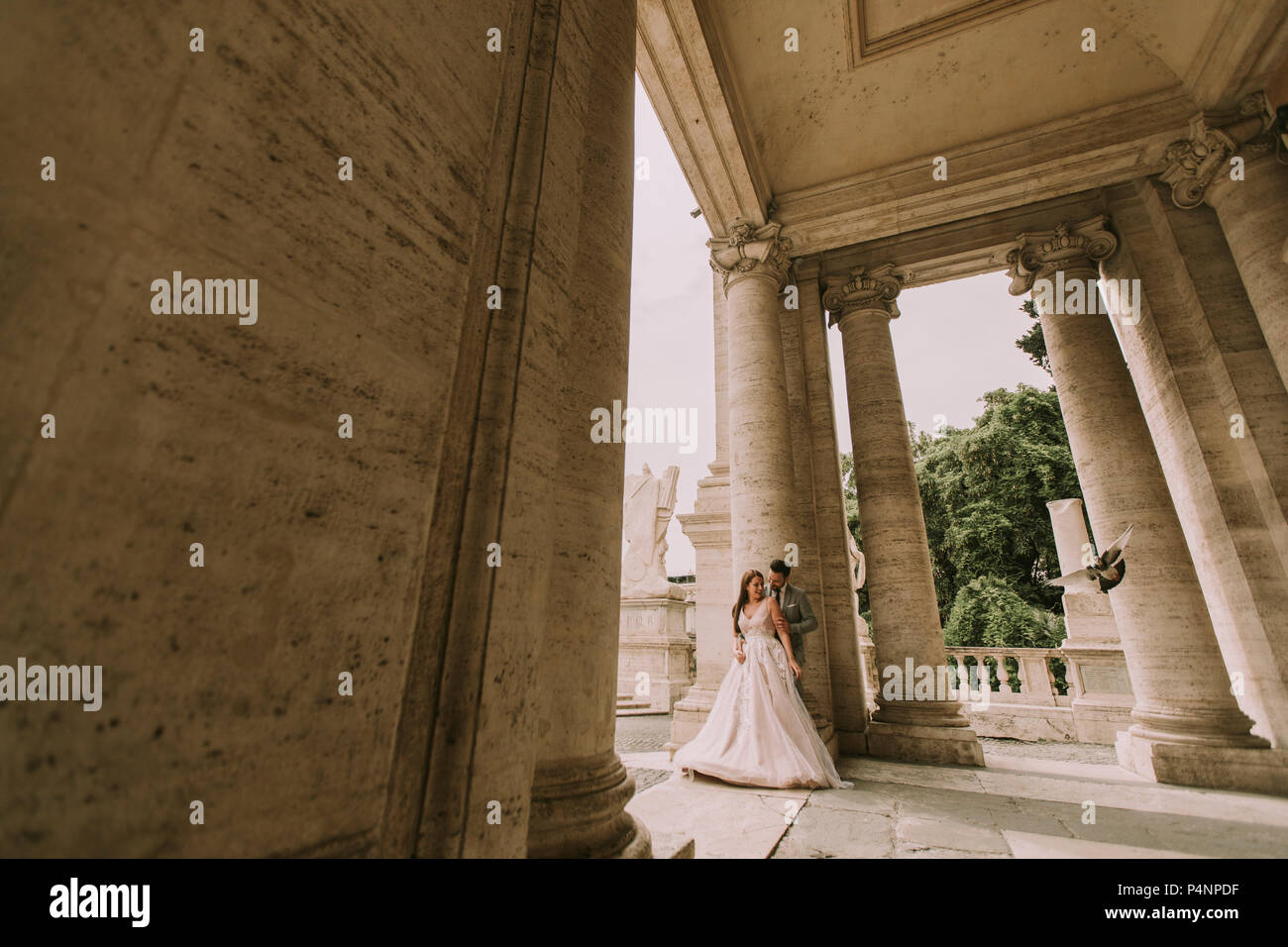 Young attractive newly married couple walking and posing in Rome with ...