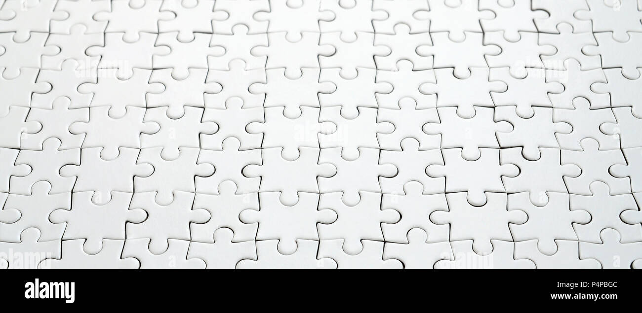 Close up of a white jigsaw puzzle in assembled state in perspective ...