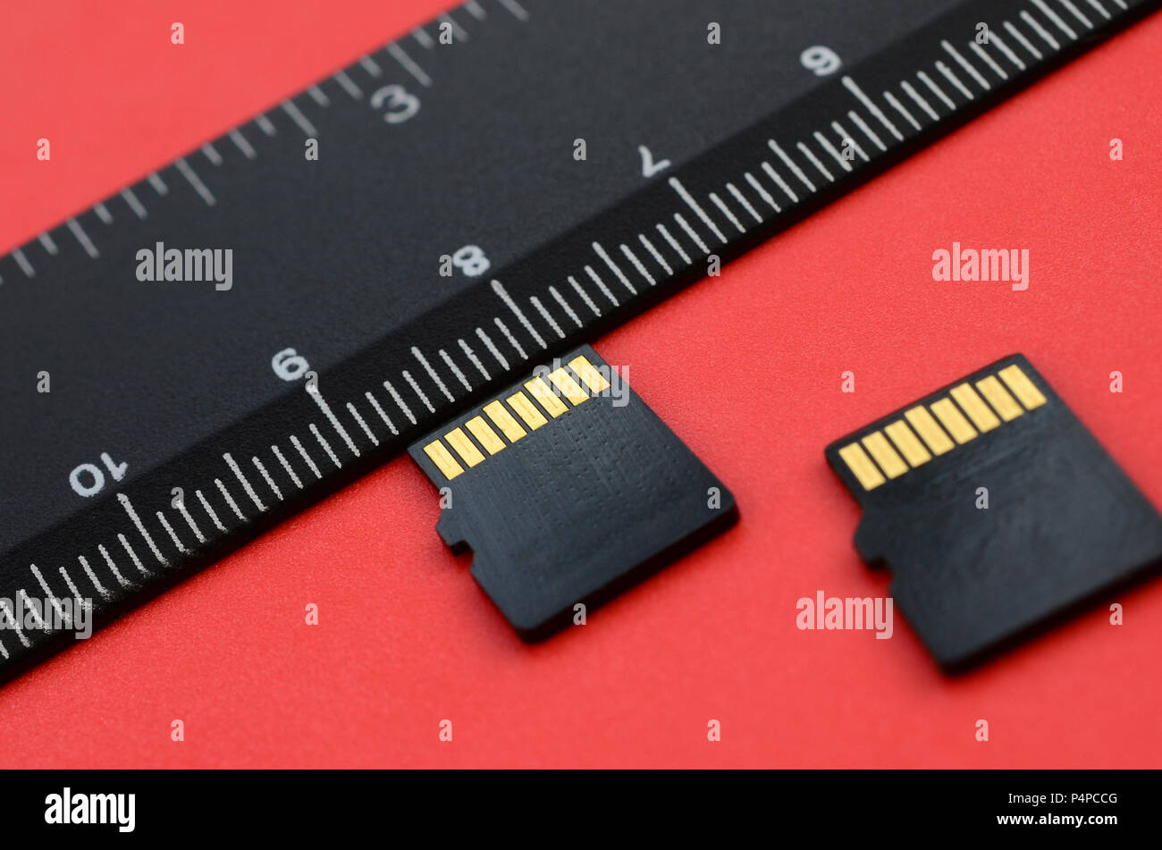 Two small micro SD memory cards lie on a red background next to a black ...