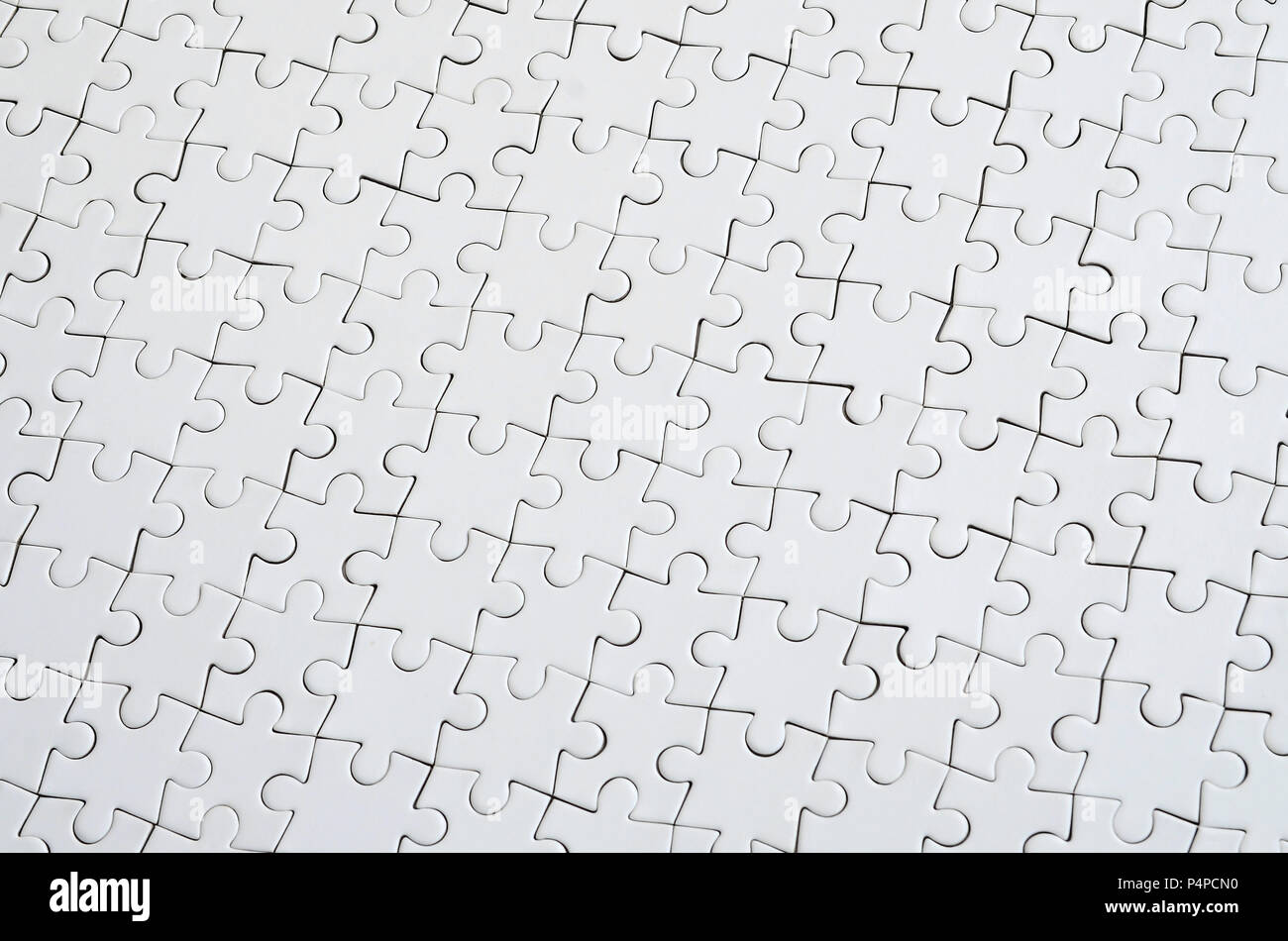 Close up texture of a white jigsaw puzzle in assembled condition. Top ...