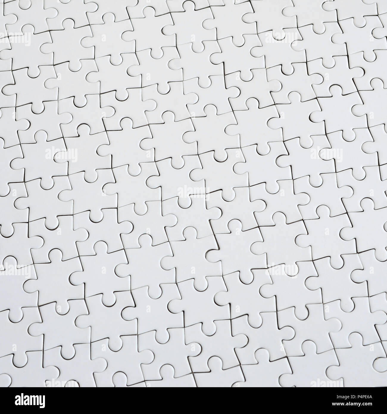 Close up texture of a white jigsaw puzzle in assembled condition. Top ...